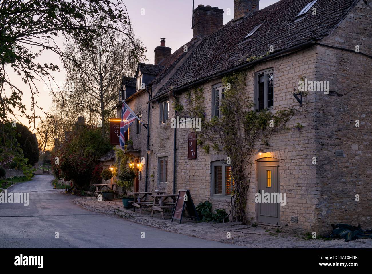 The Three Horseshoes pub at dusk in the village of Asthall near Burford ...