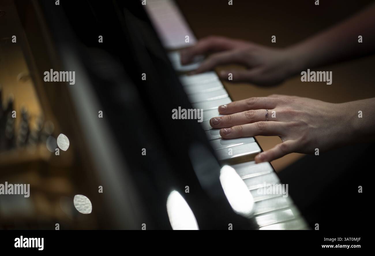 Hands of a young pianist playing on the keyboard of a Steinway & Sons ...