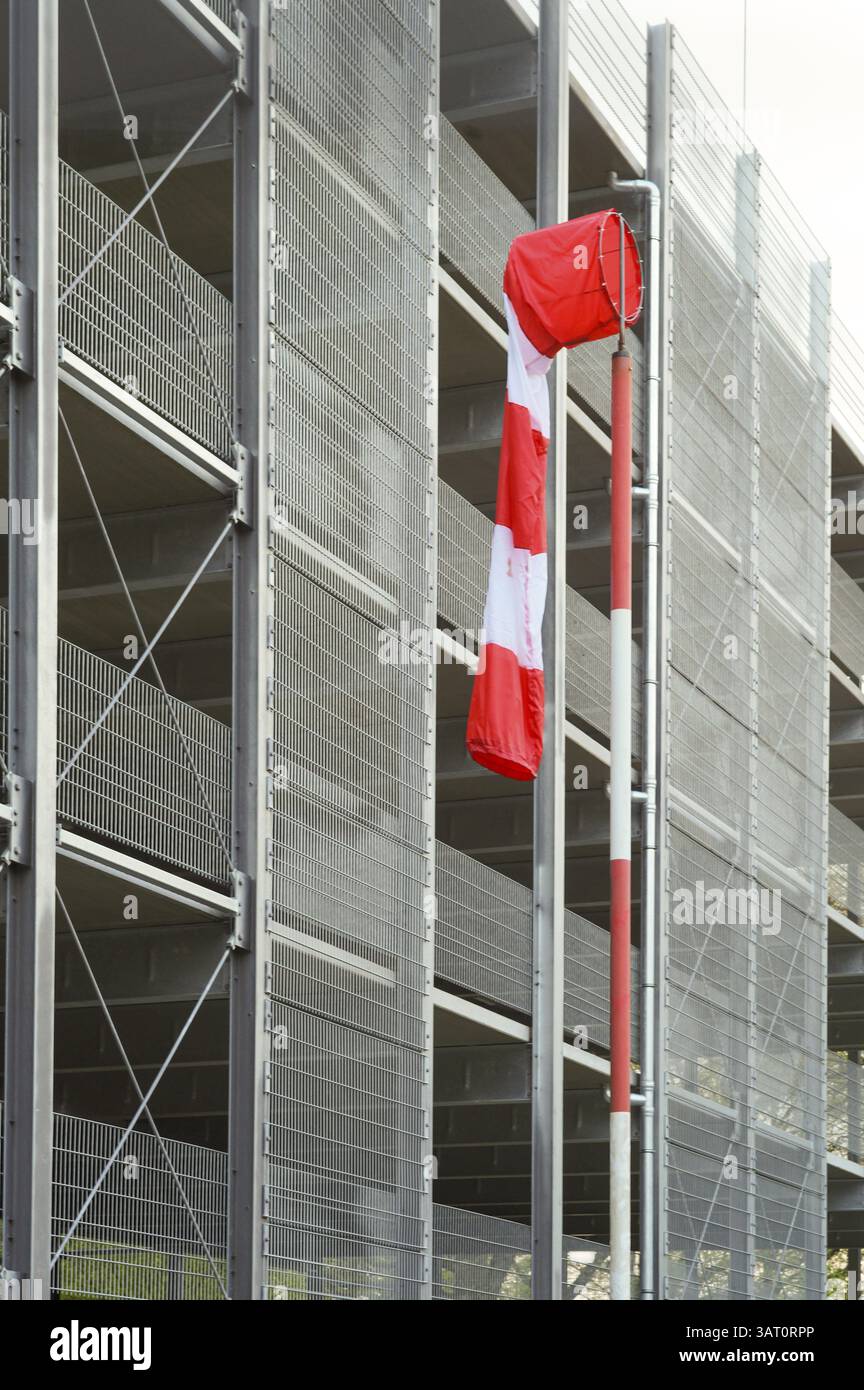 Red and white windsock indicating wind direction, attached to a pole on ...