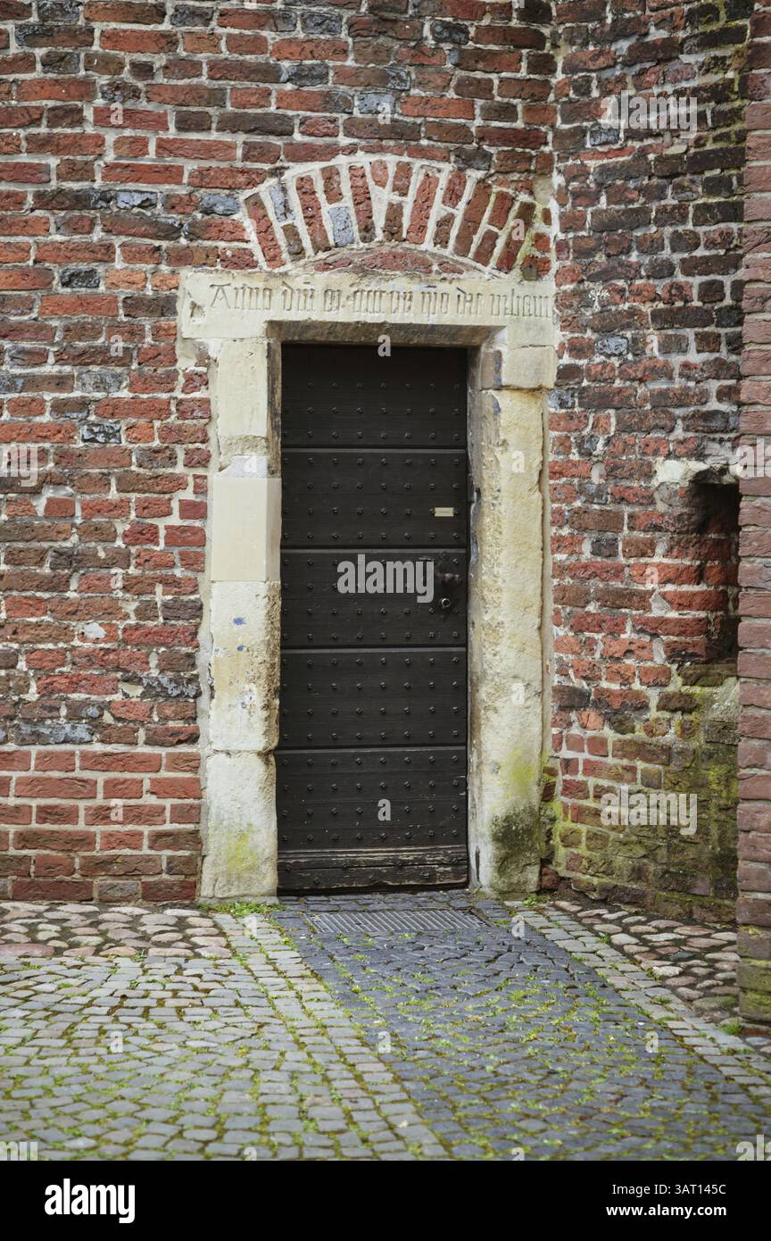 Ancient wooden door set within a weathered brick wall, featuring a ...