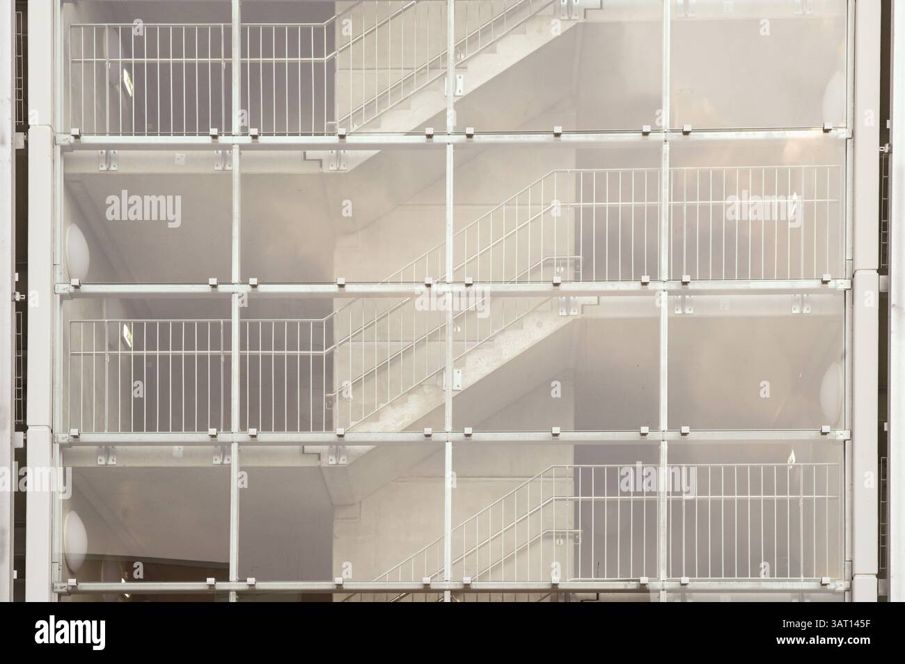 Glass facade of a modern building revealing staircases with metal ...