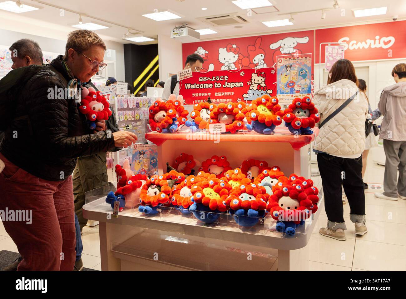Foreign tourists pick up and look Myakumyaku souvenirs at a shop in ...