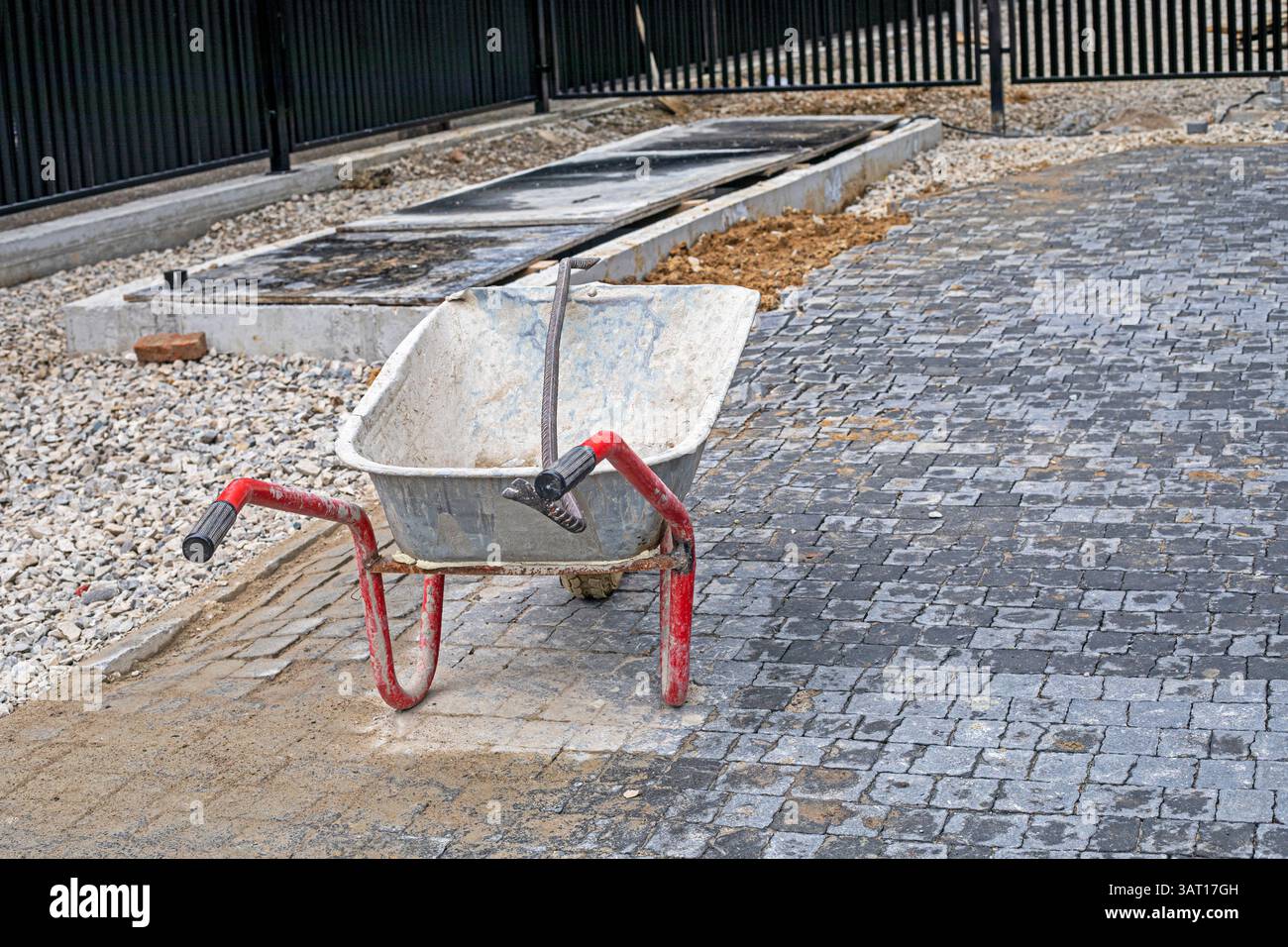 wheelbarrow near small gravel and crushed stone when laying street ...