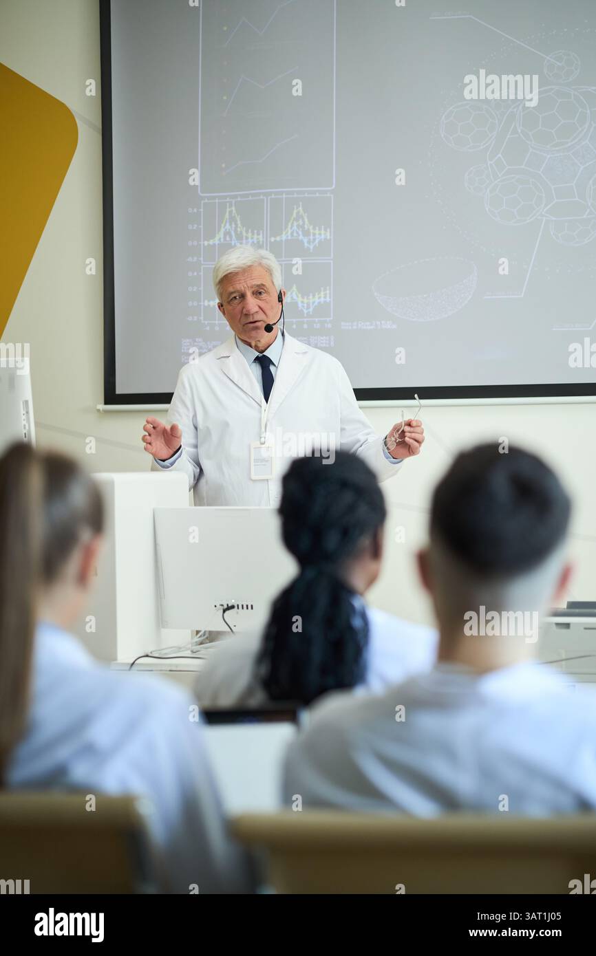 Elderly doctor explaining medical concepts to a group of students ...