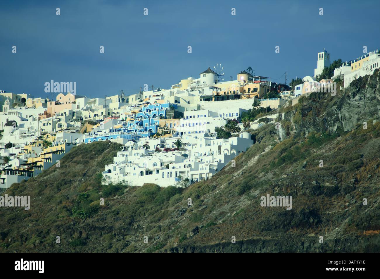 White and blue Cycladic homes built into the steep cliffside of ...