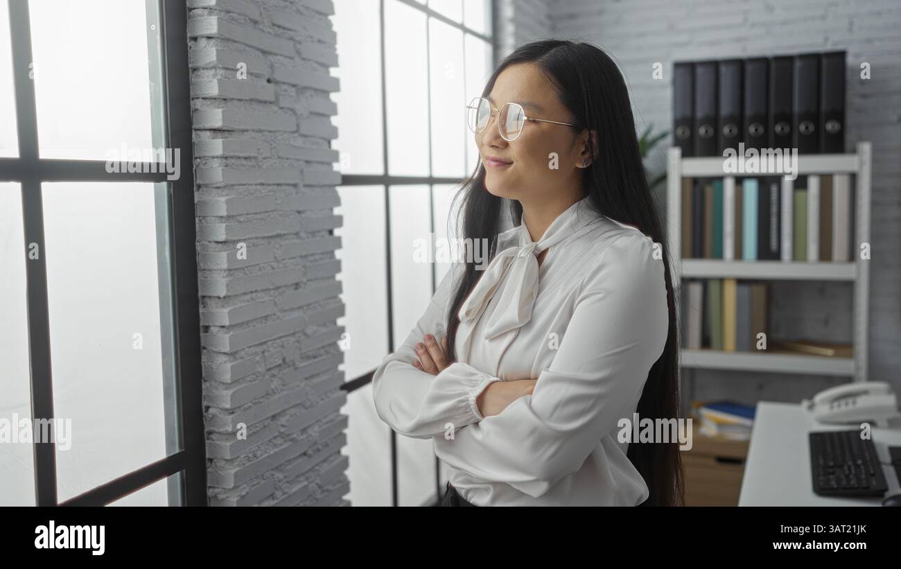 Woman with crossed arms stands confidently in office room with white ...