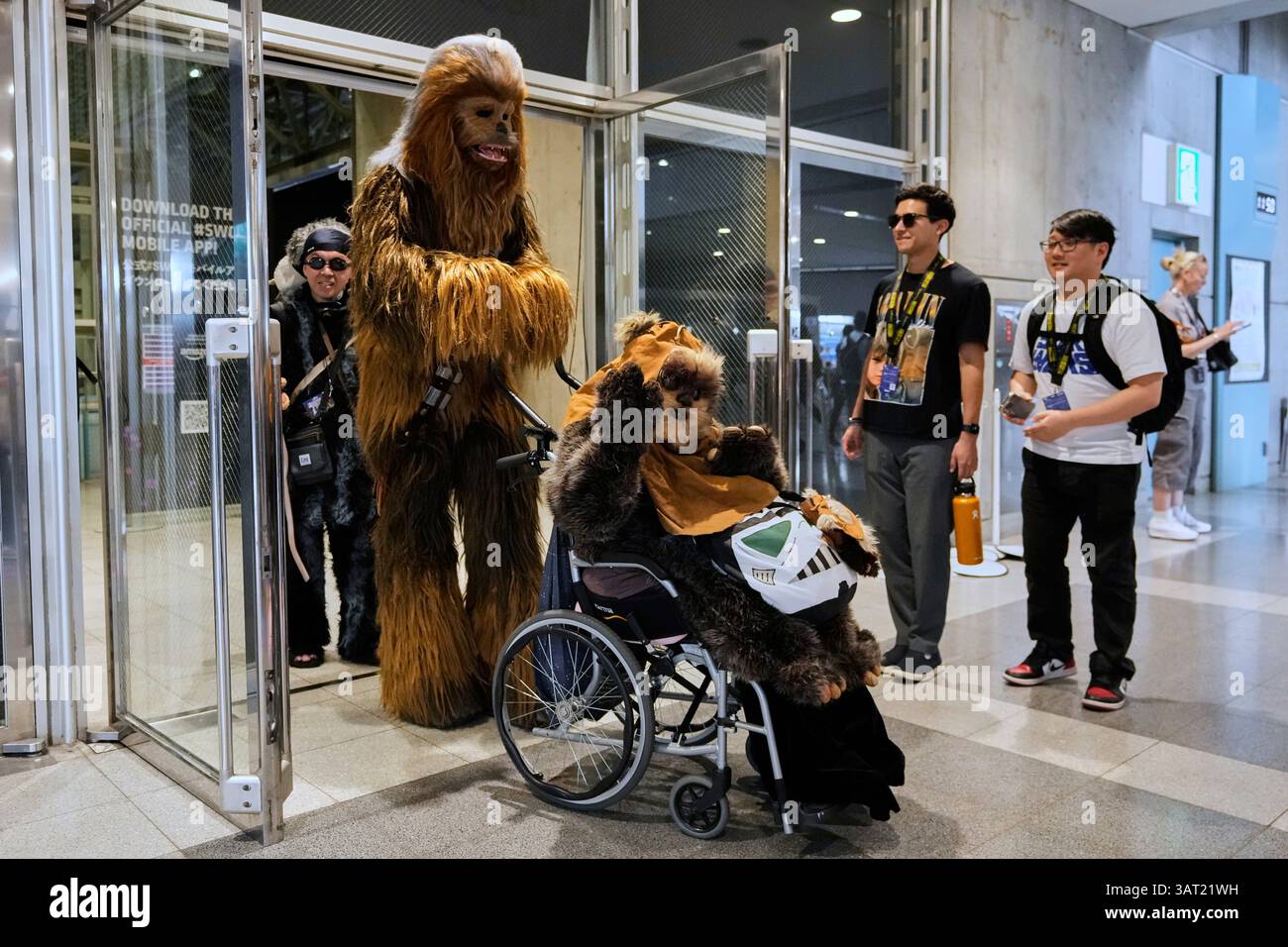Star Wars fans wearing costumes of Chewbacca, left, and Widdle Warrick ...