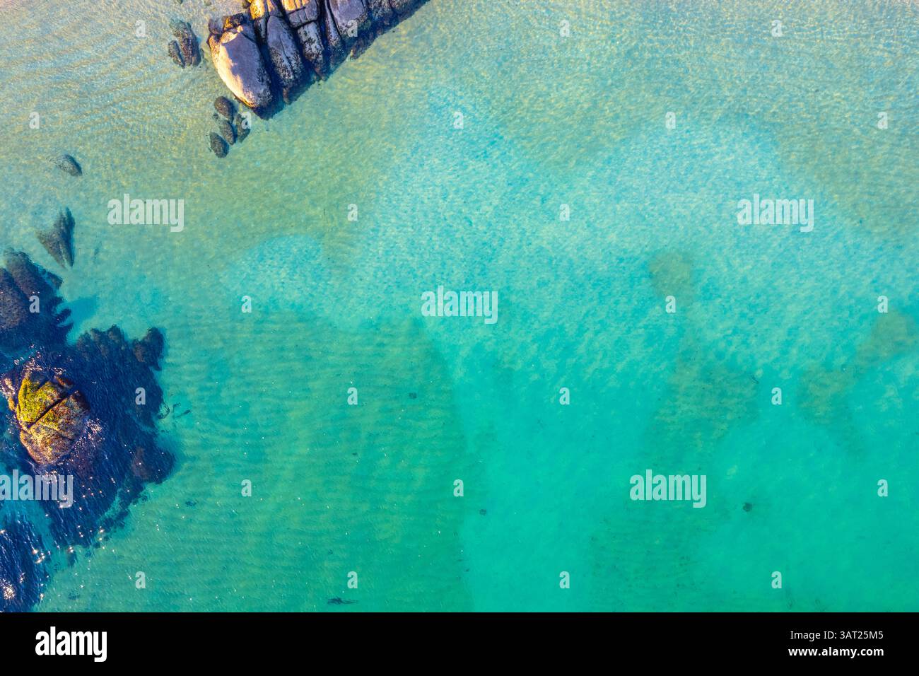 aerial top down drone view of clear turquoise water and coastal rocks ...