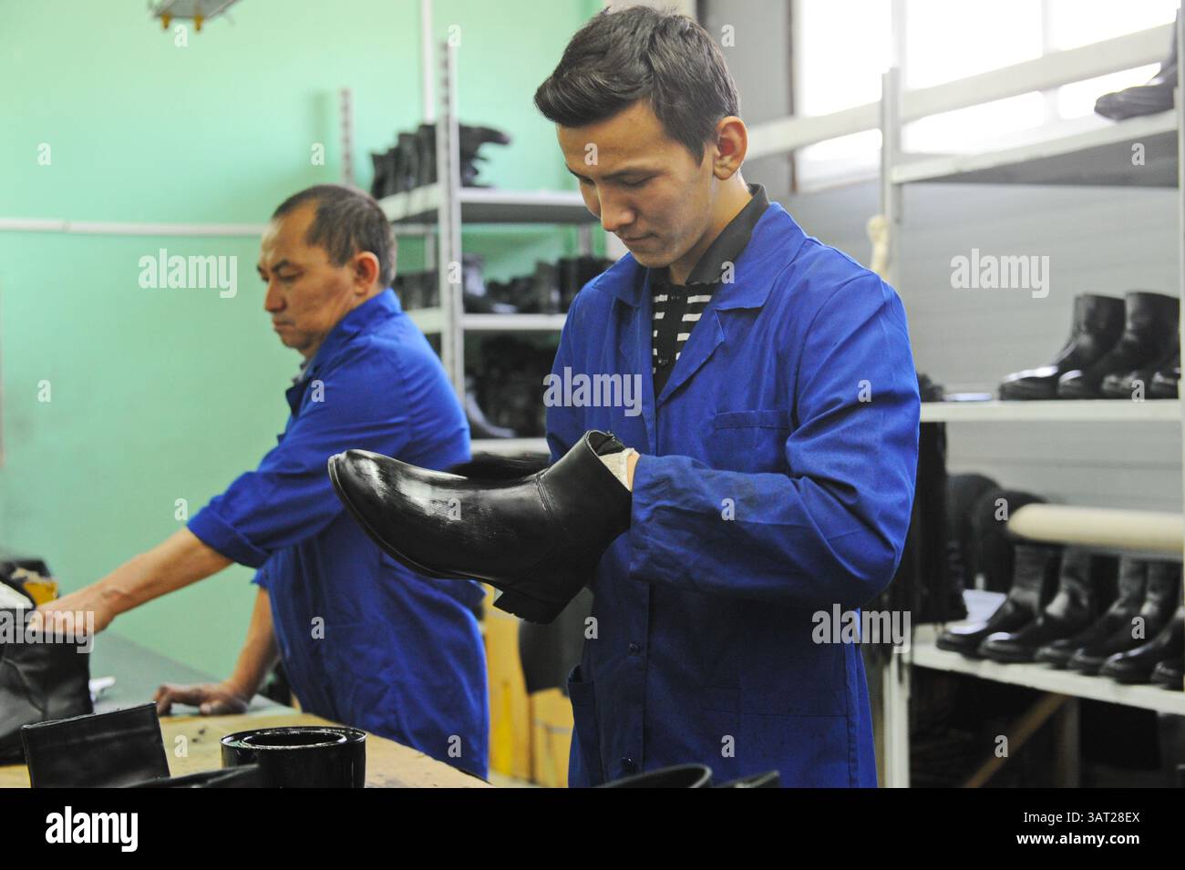 Workers are engaged in sewing shoes in the shop Stock Photo - Alamy