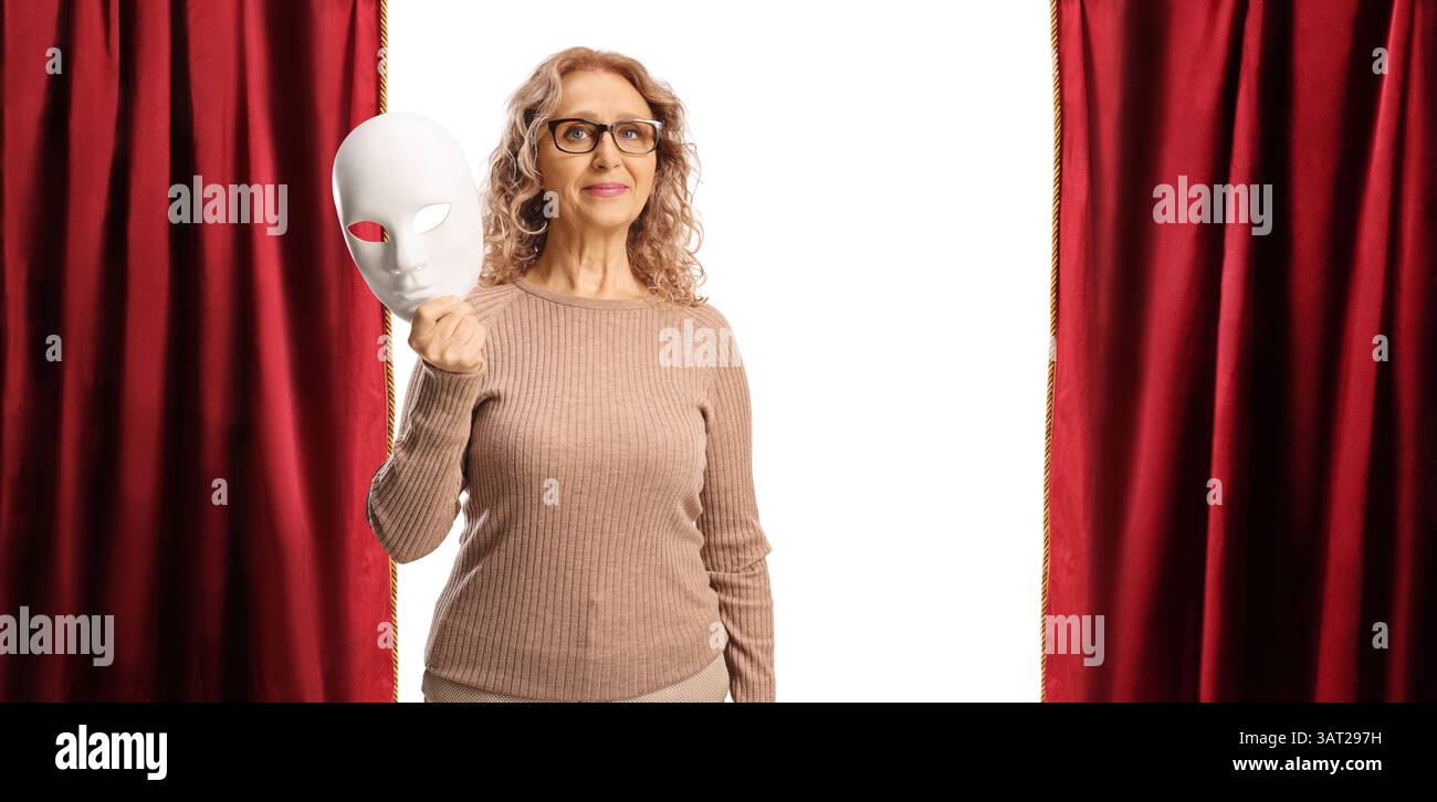 Middle aged woman holding a mask on a theatre stage isolated on white ...