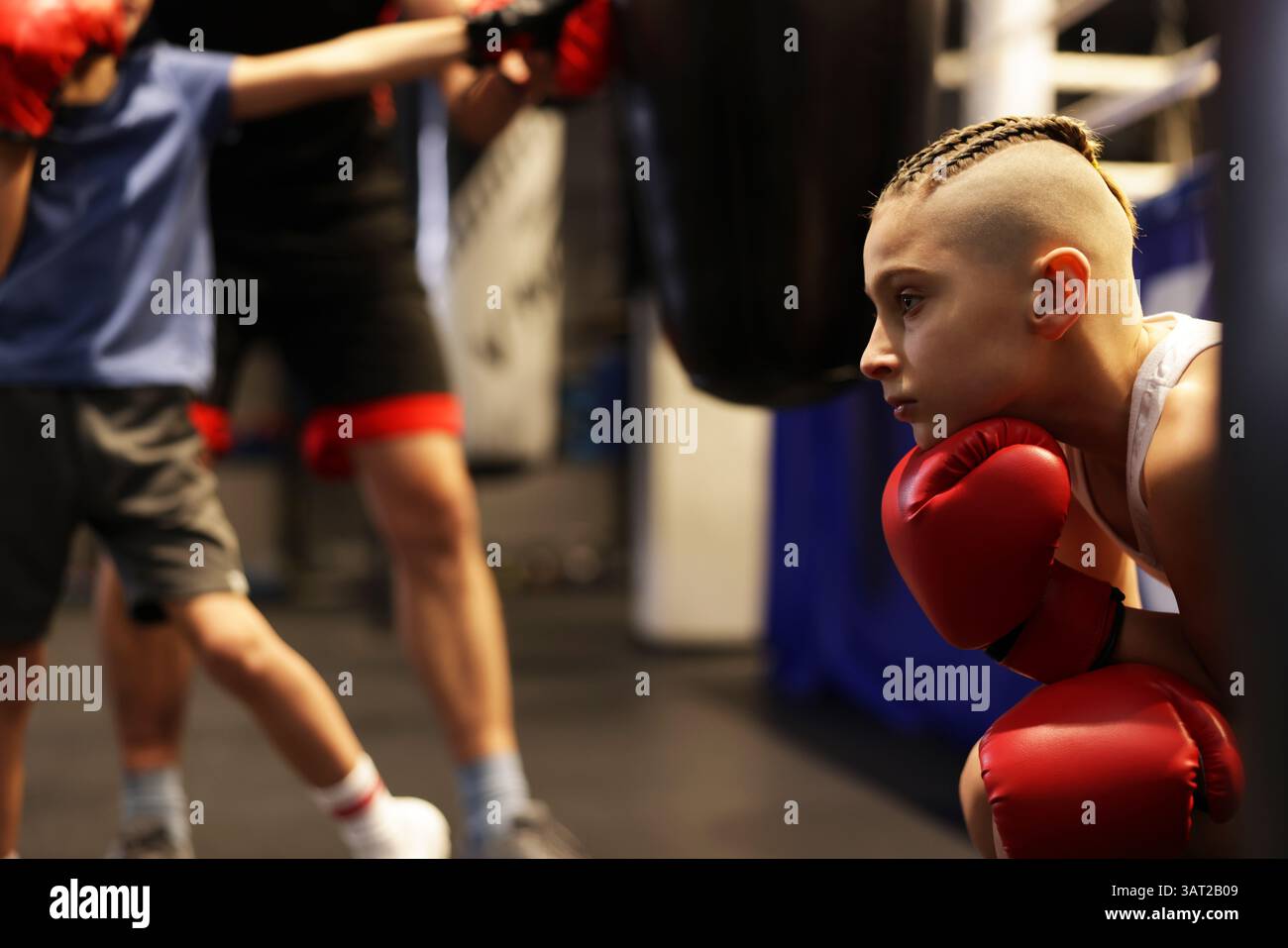 Children having boxing practice with their coach in training center ...