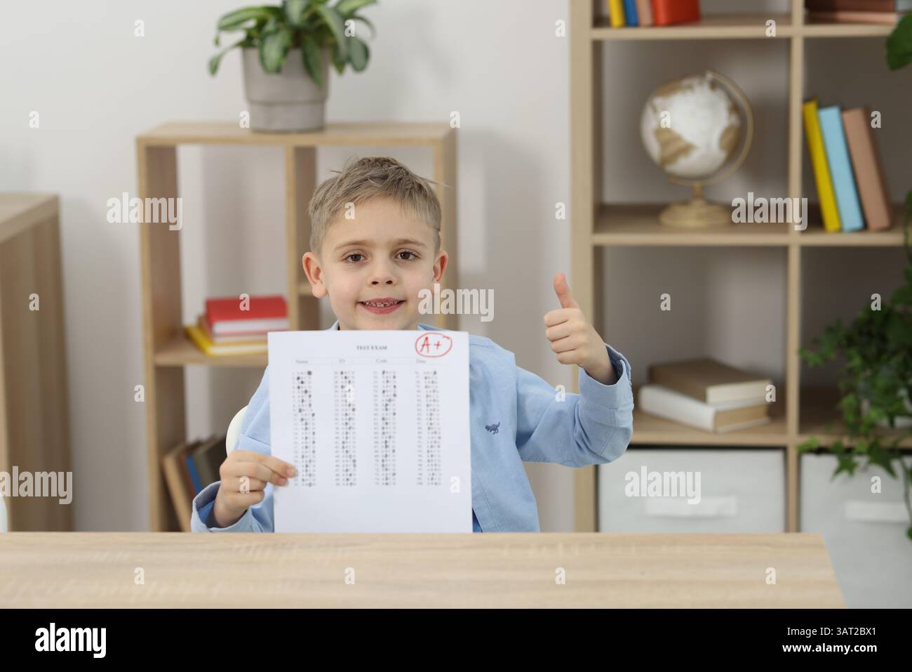 School grade. Happy boy holding answer sheet with letter A and plus ...