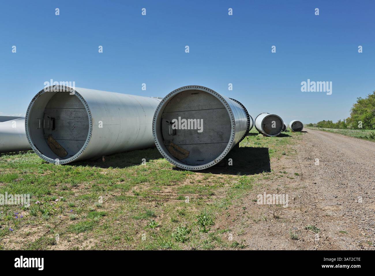 New parts of wind turbines are laid out in an open field for subsequent ...