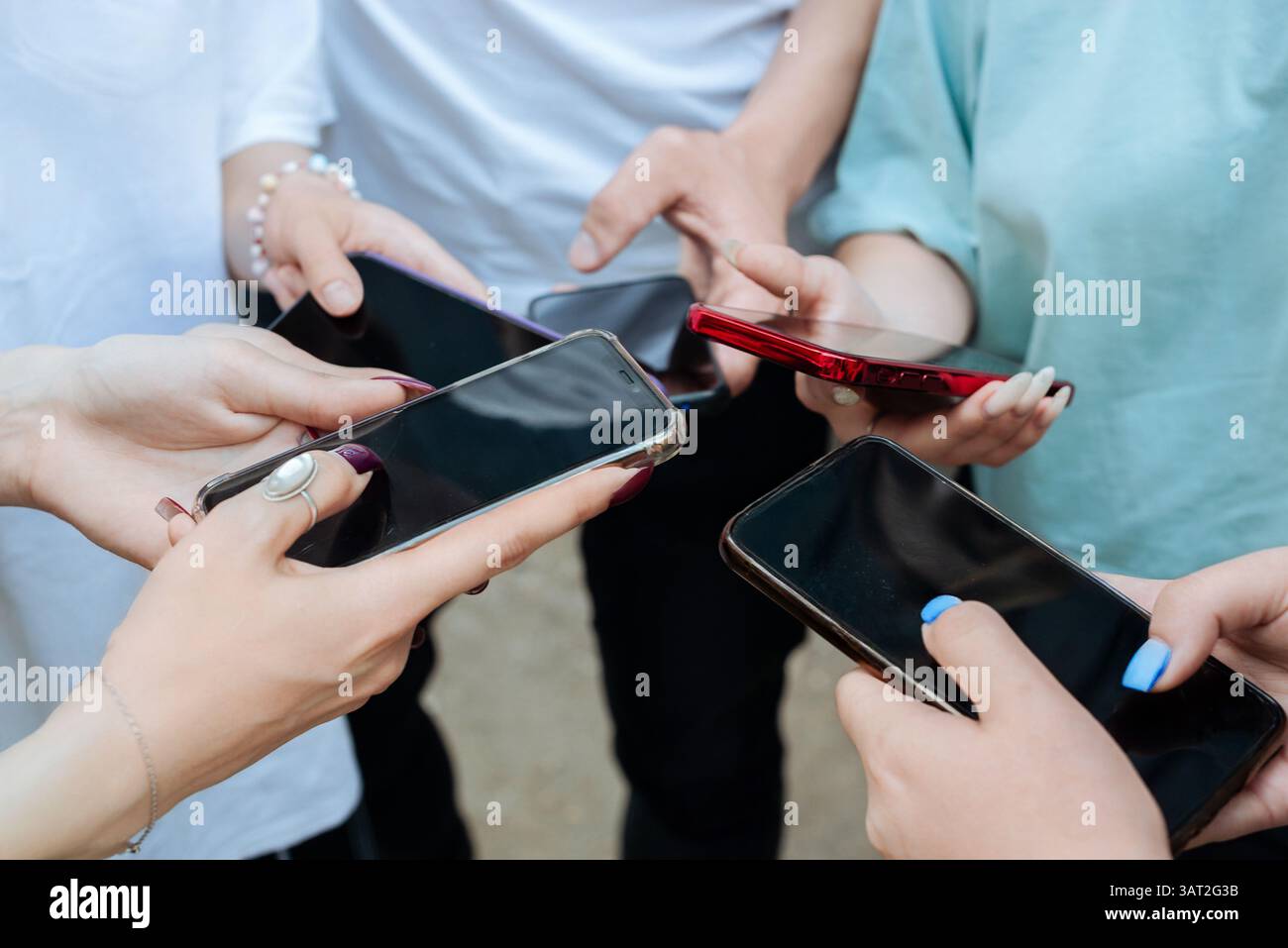 Hands of teens holding smartphones outdoors Stock Photo - Alamy