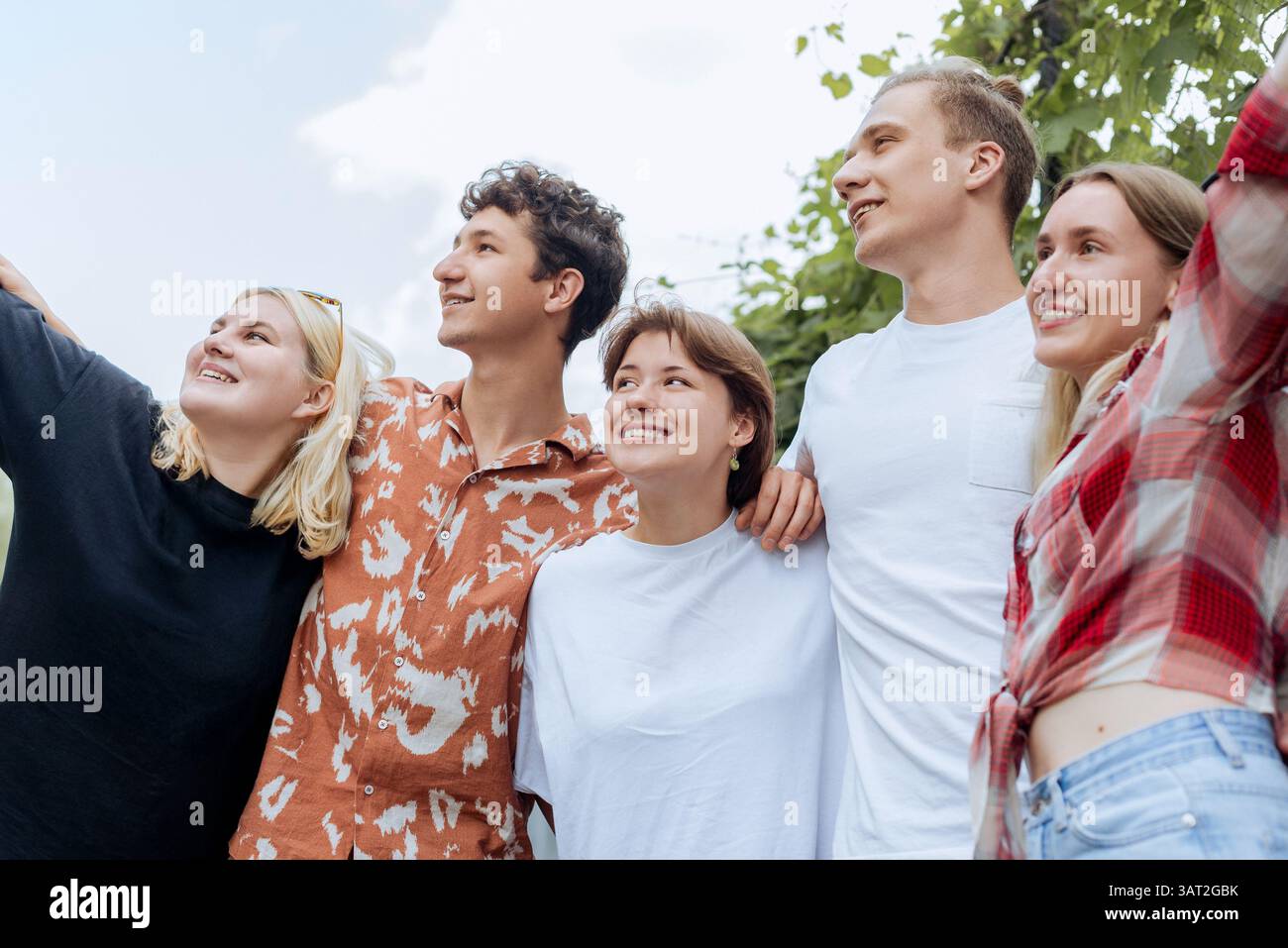 Group of young friends smiling under blue sky Stock Photo - Alamy