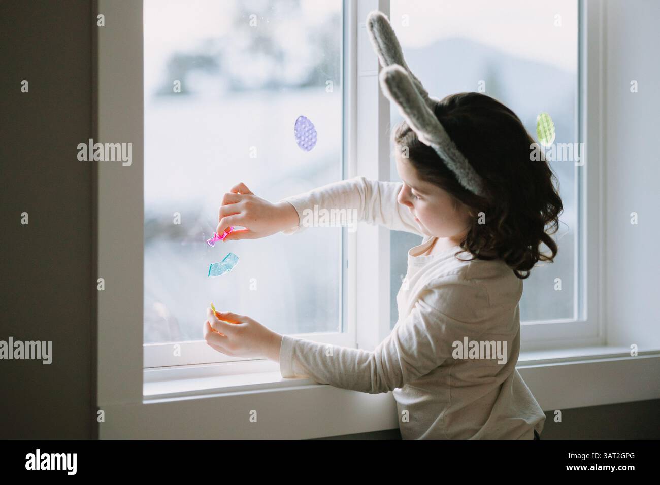 Child decorating window with Easter stickers and eggs Stock Photo - Alamy