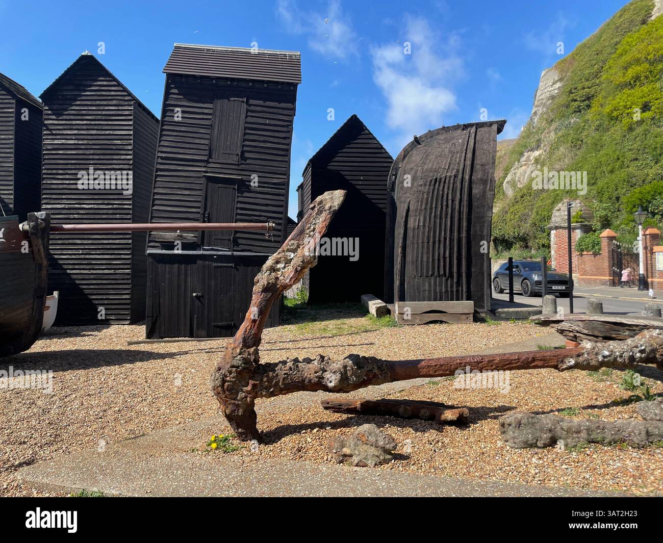 a giant rusty anchor and old fishing net huts painted matt black at ...