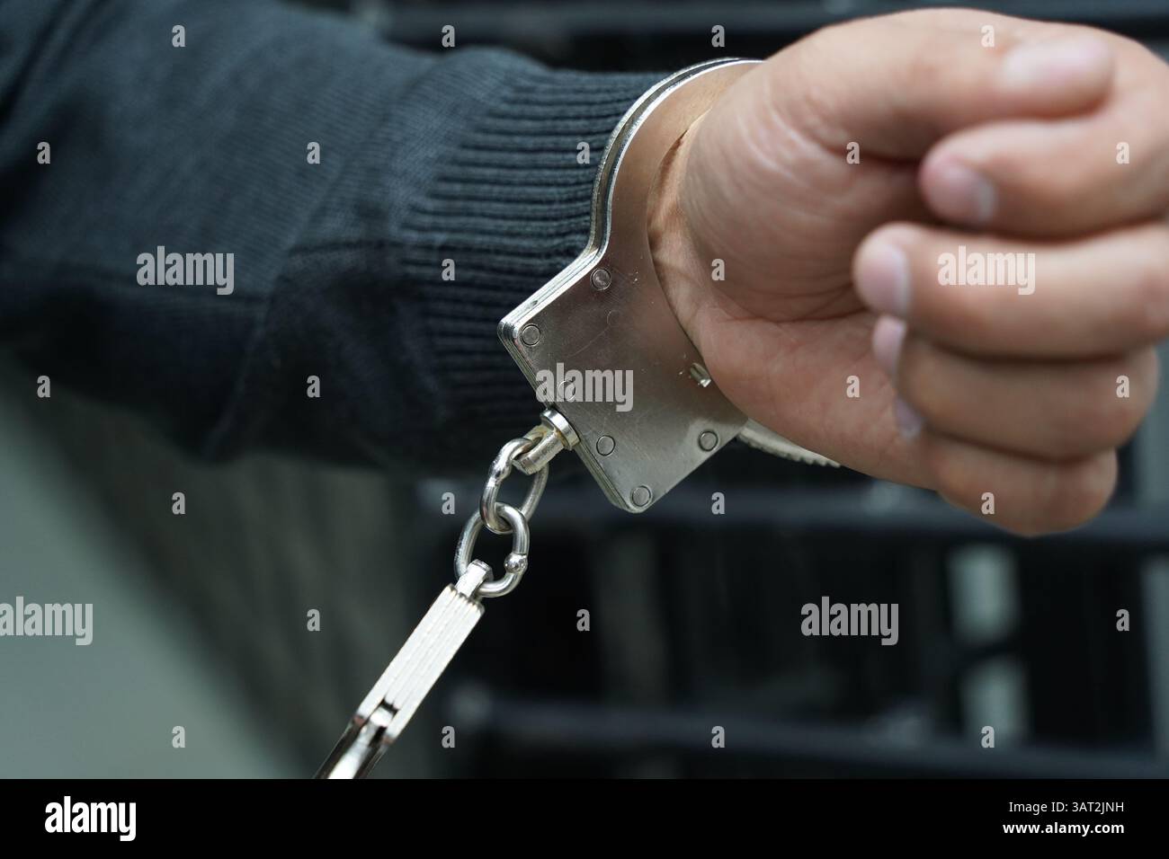 Handcuffs are hanging on the bars of the door of the detention center ...