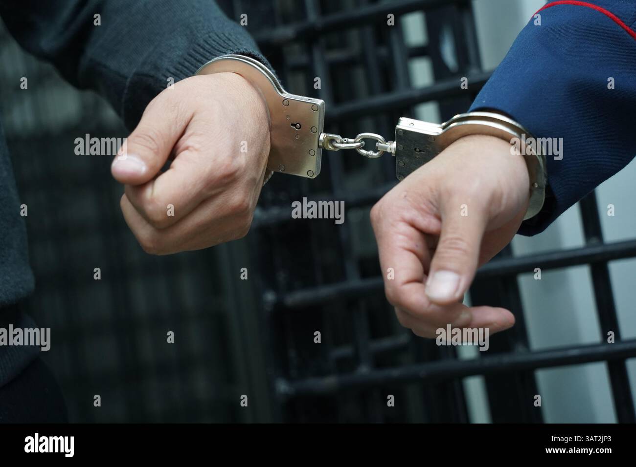 Handcuffs are hanging on the bars of the door of the detention center ...