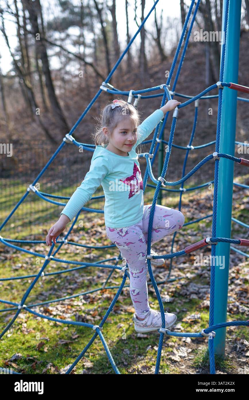 Girl Climbing Rope Net at Playground Stock Photo - Alamy