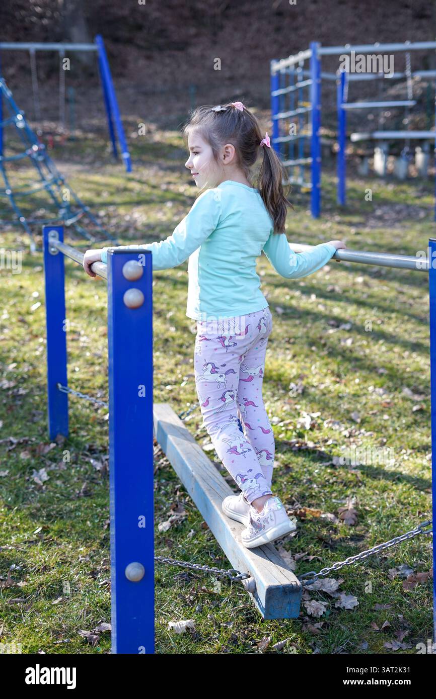 Girl Balancing on Playground Beam Stock Photo - Alamy