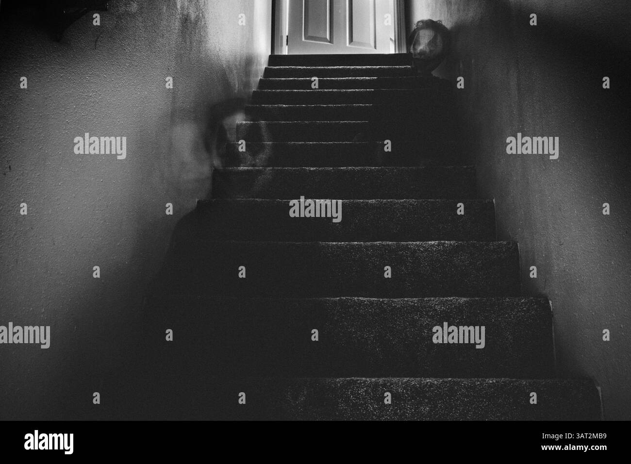 Scary halloween ghost clowns sit on spooky lit staircase Stock Photo ...