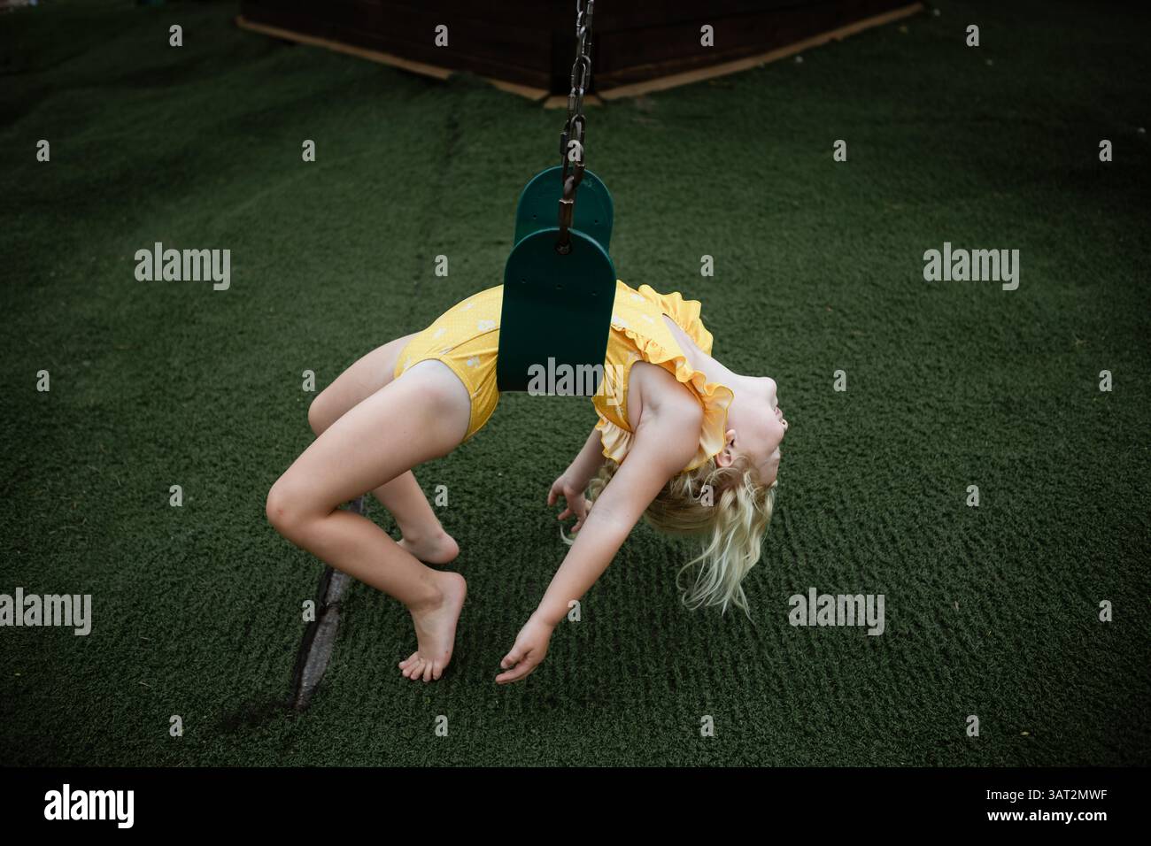 Giggling young child being silly on playground swing Stock Photo - Alamy