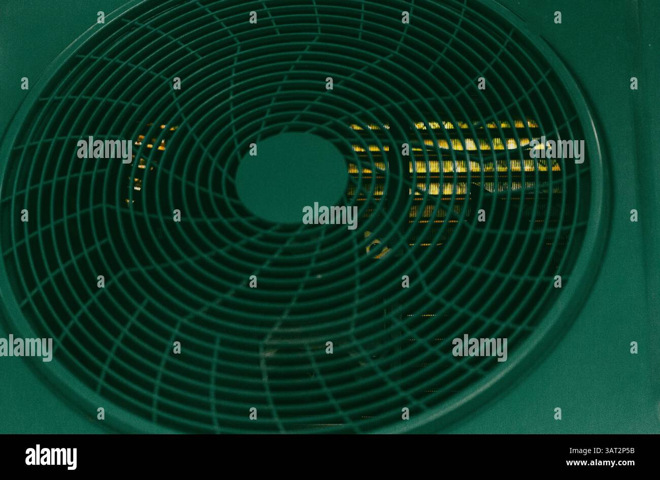 A close-up view of a green air conditioner unit's protective grill and ...