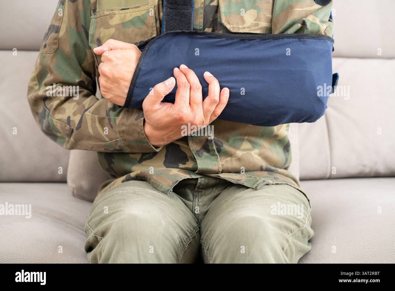 Close up of a disabled soldier grabbing his painful bandaged arm on a ...