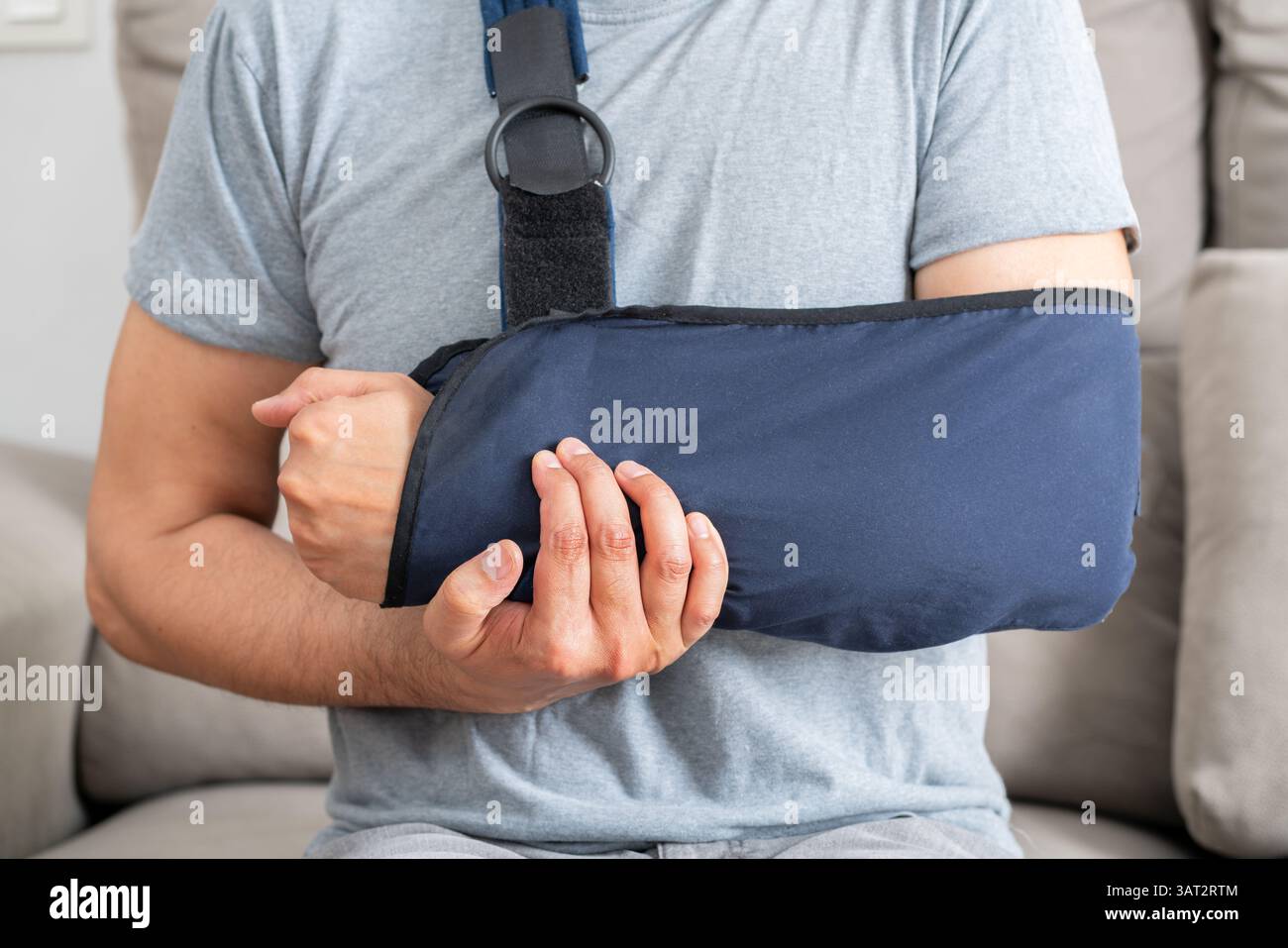Close up portrait of a disabled man grabbing his painful bandaged arm ...