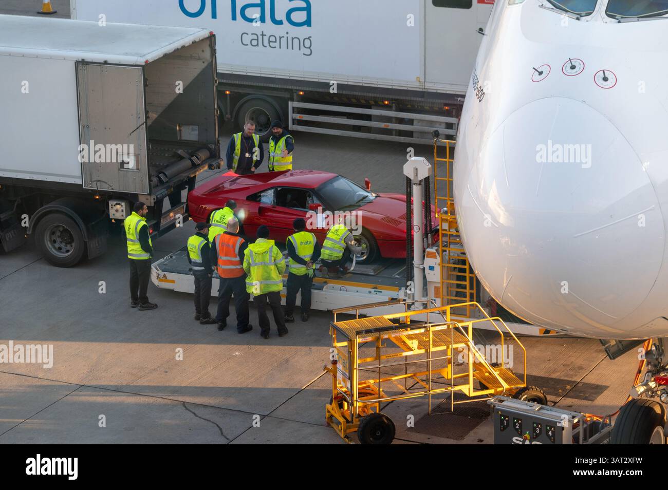 Air cargo crew carefully unloading of a high performance Ferrari car ...