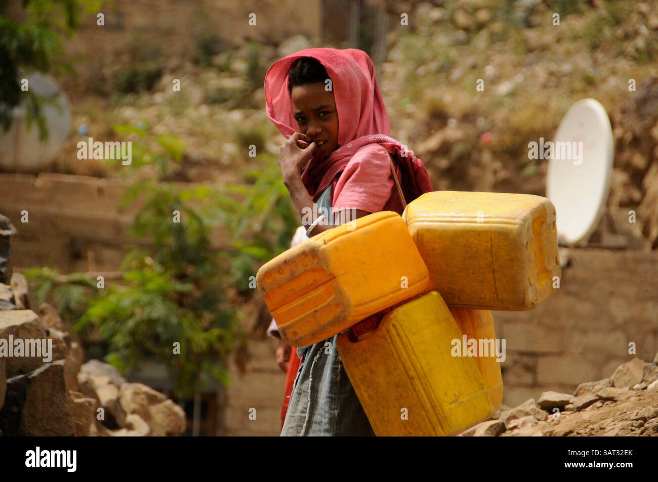 July 18, 2013 - Sana'a, Yemen - A Yemeni girl carries bottles as she ...