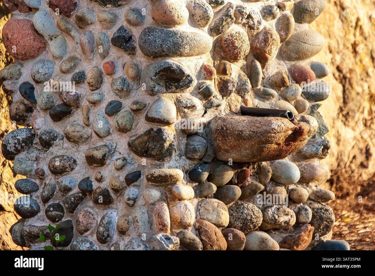 Detail of a traditional pebble fountain by the roadside. Cargèse, Corsica, France, typical and ...