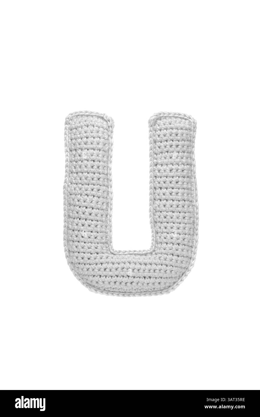 Handmade crocheted letter U in light grey yarn, isolated on white ...