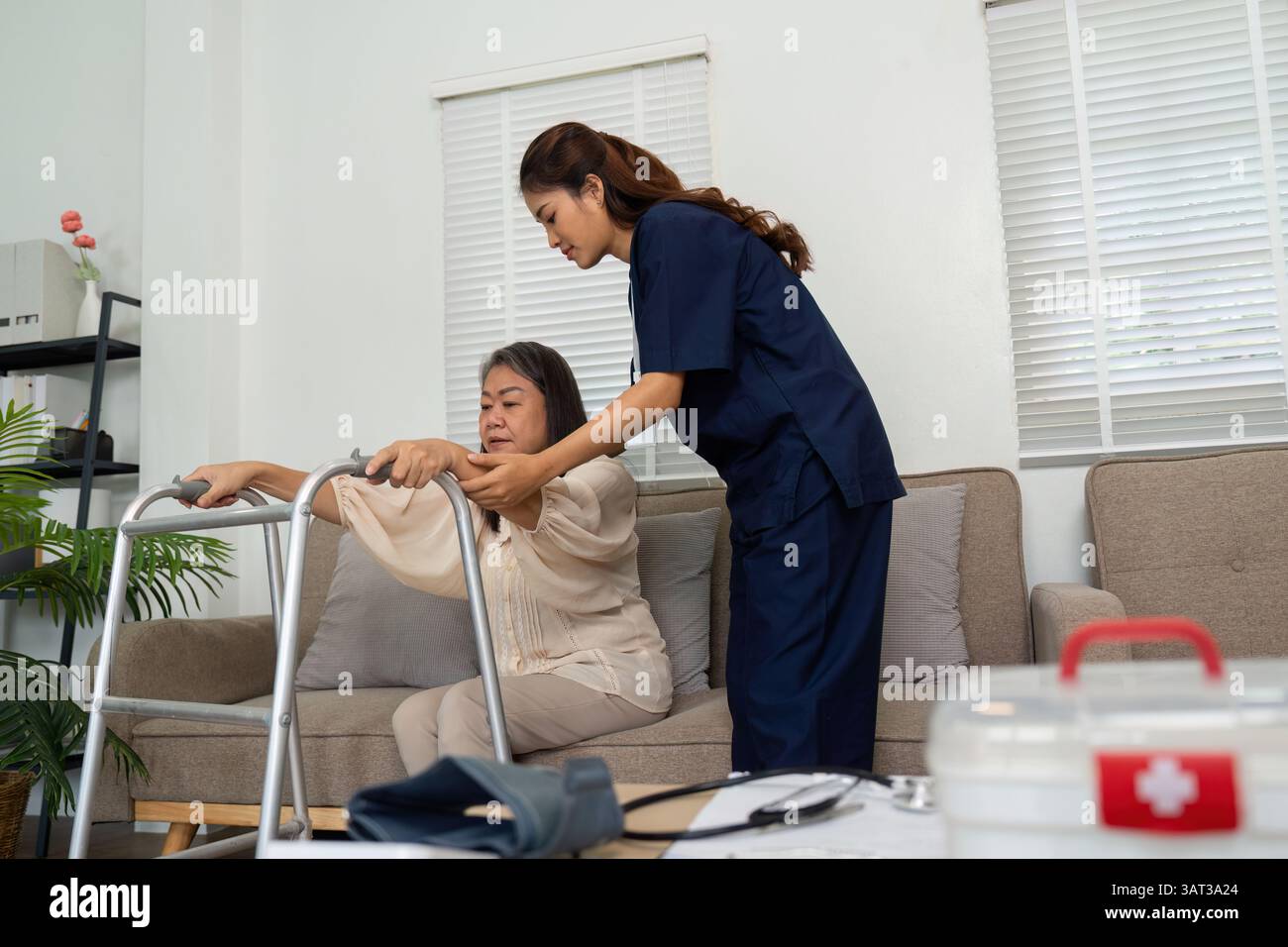 Mobility Assistance and Elderly Care. A caregiver supports an elderly woman while she uses a ...