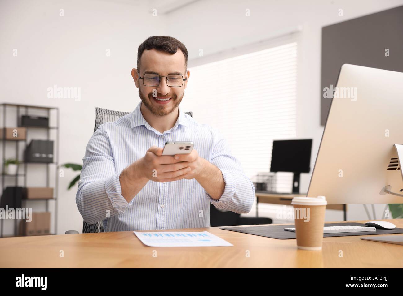 Man taking photo of document using scanning app on smartphone at desk ...