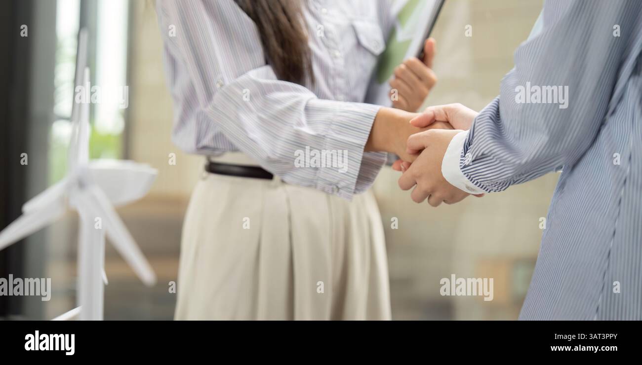 Collaboration and Sustainability. Two professionals shaking hands in an ...