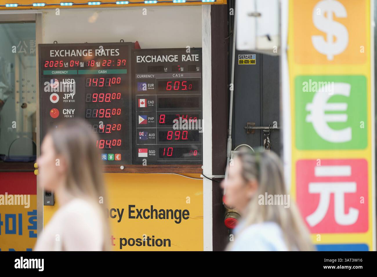 A visitor walks near an electronic foreign currency exchange rates ...