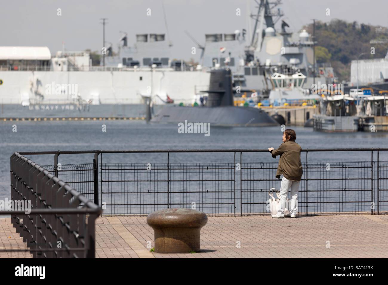 A woman at a promenade looks at Japanese warships inside the Japan ...