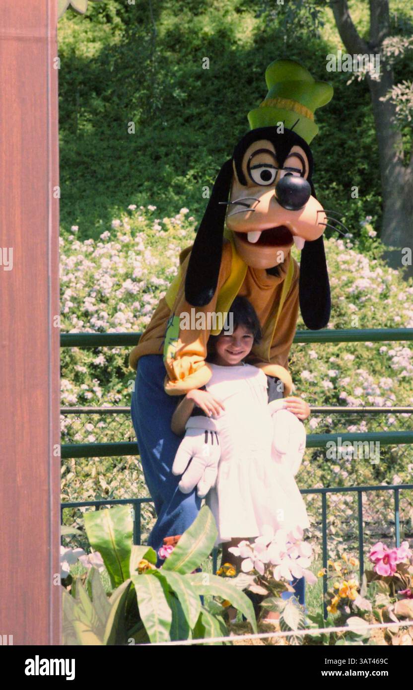Anaheim, CA, USA, approx. 1985. Child posing with Goofy at Disneyland ...