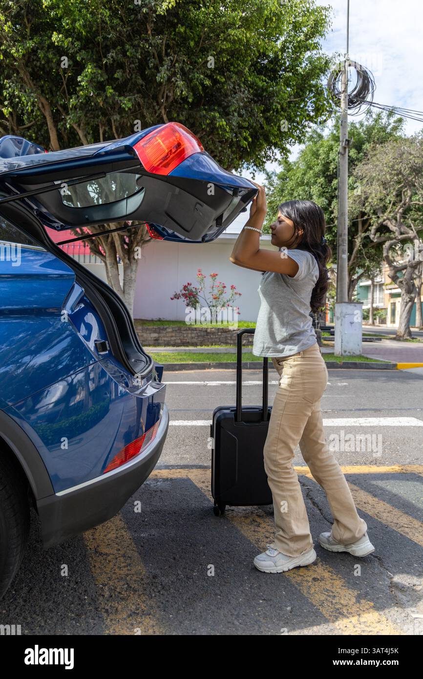 A teenager is getting ready to leave her car and is pulling out a ...