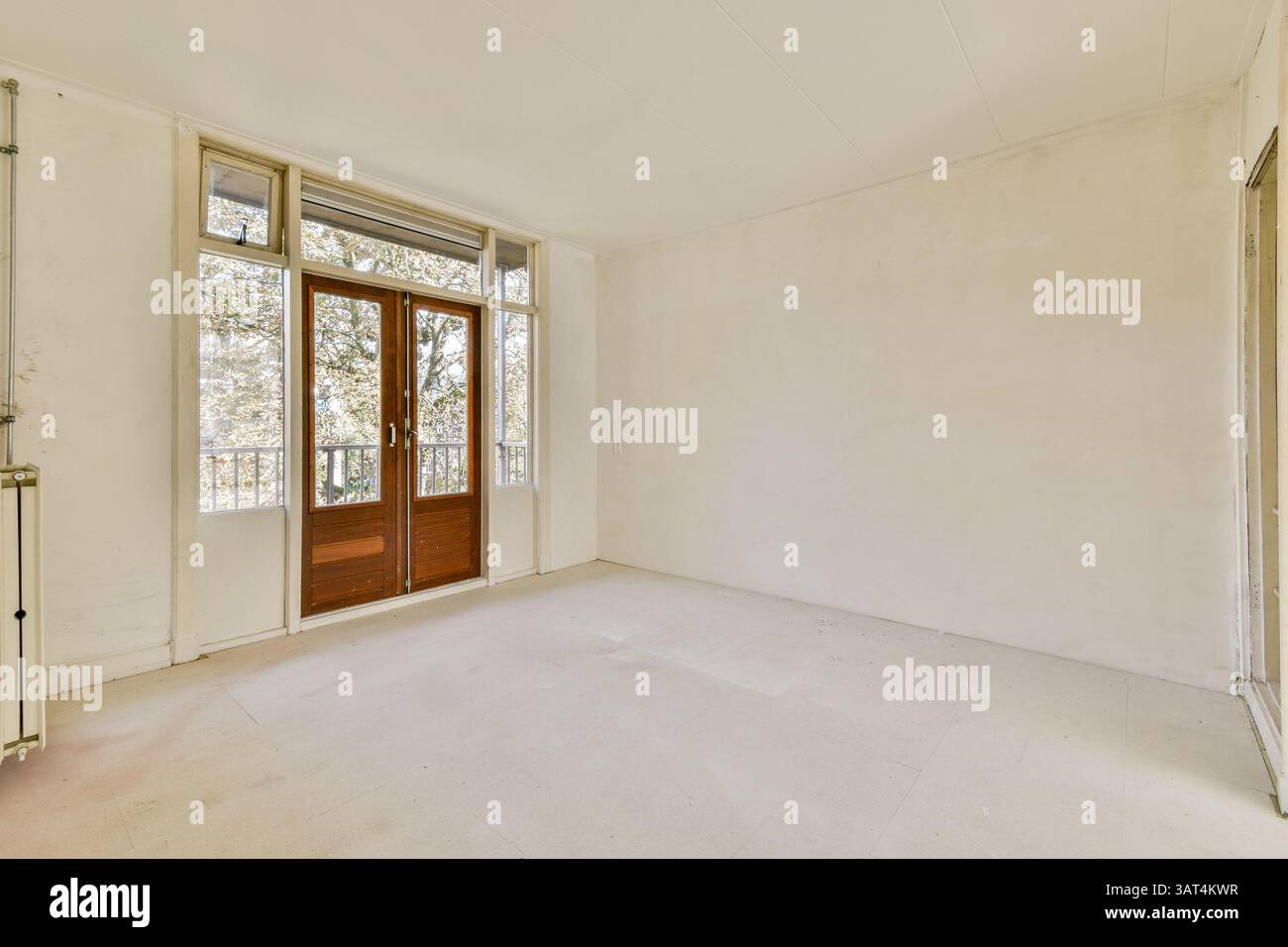 A vacant room featuring large windows that allow natural light to flood ...