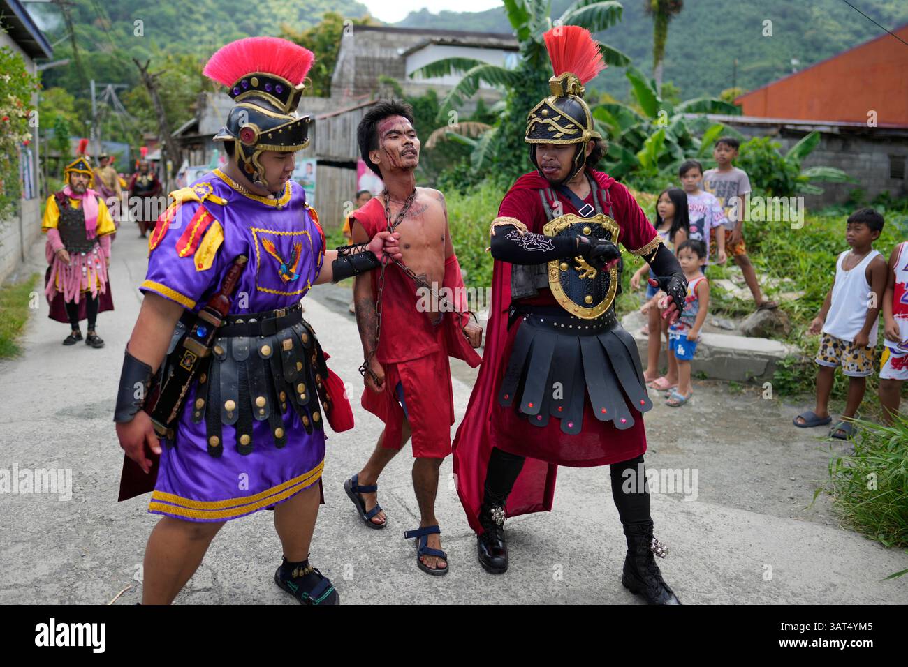Performers dressed as Roman soldiers push a man playing the role of ...