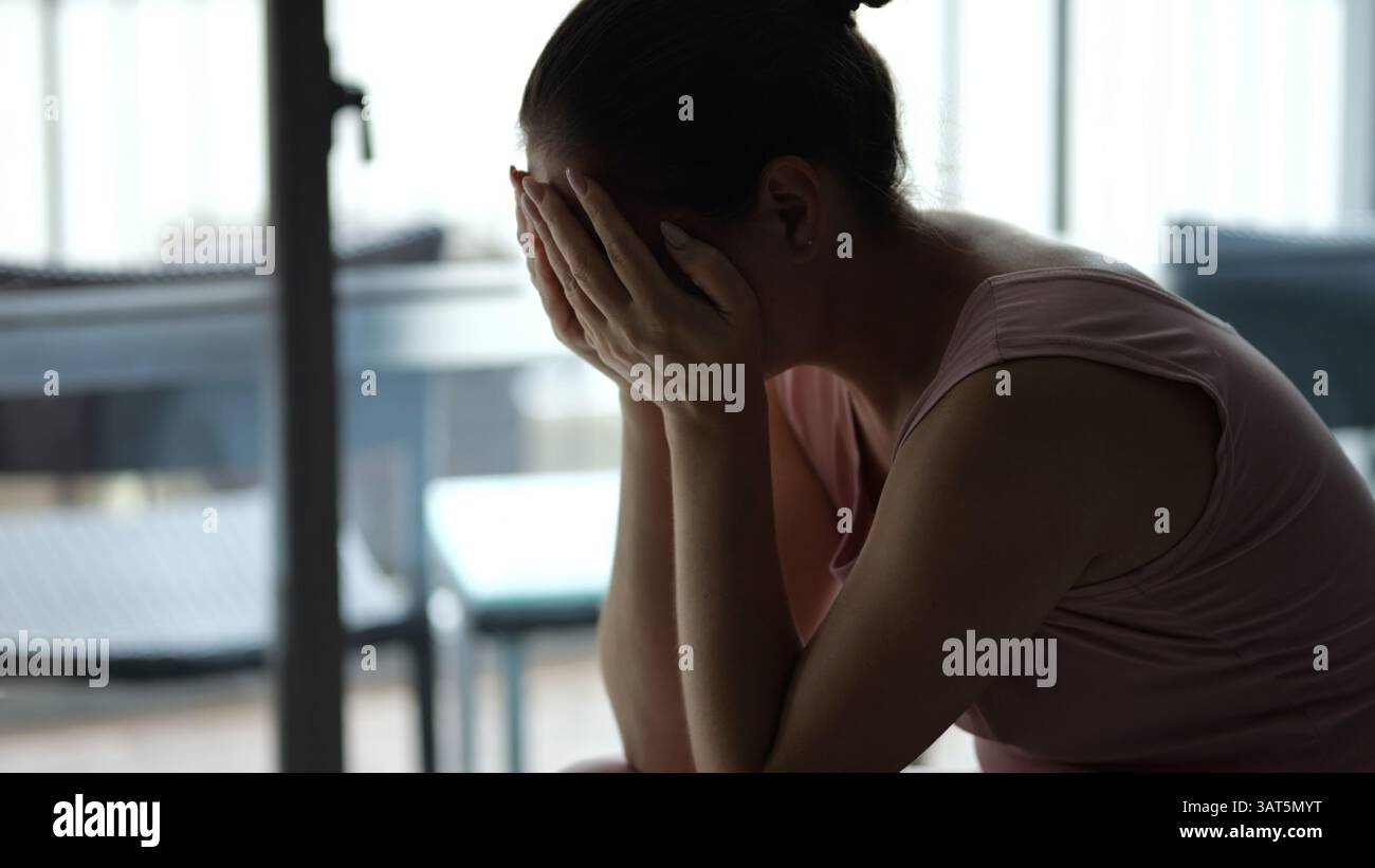 Sad woman crying covering face with hands at hotel Stock Photo - Alamy