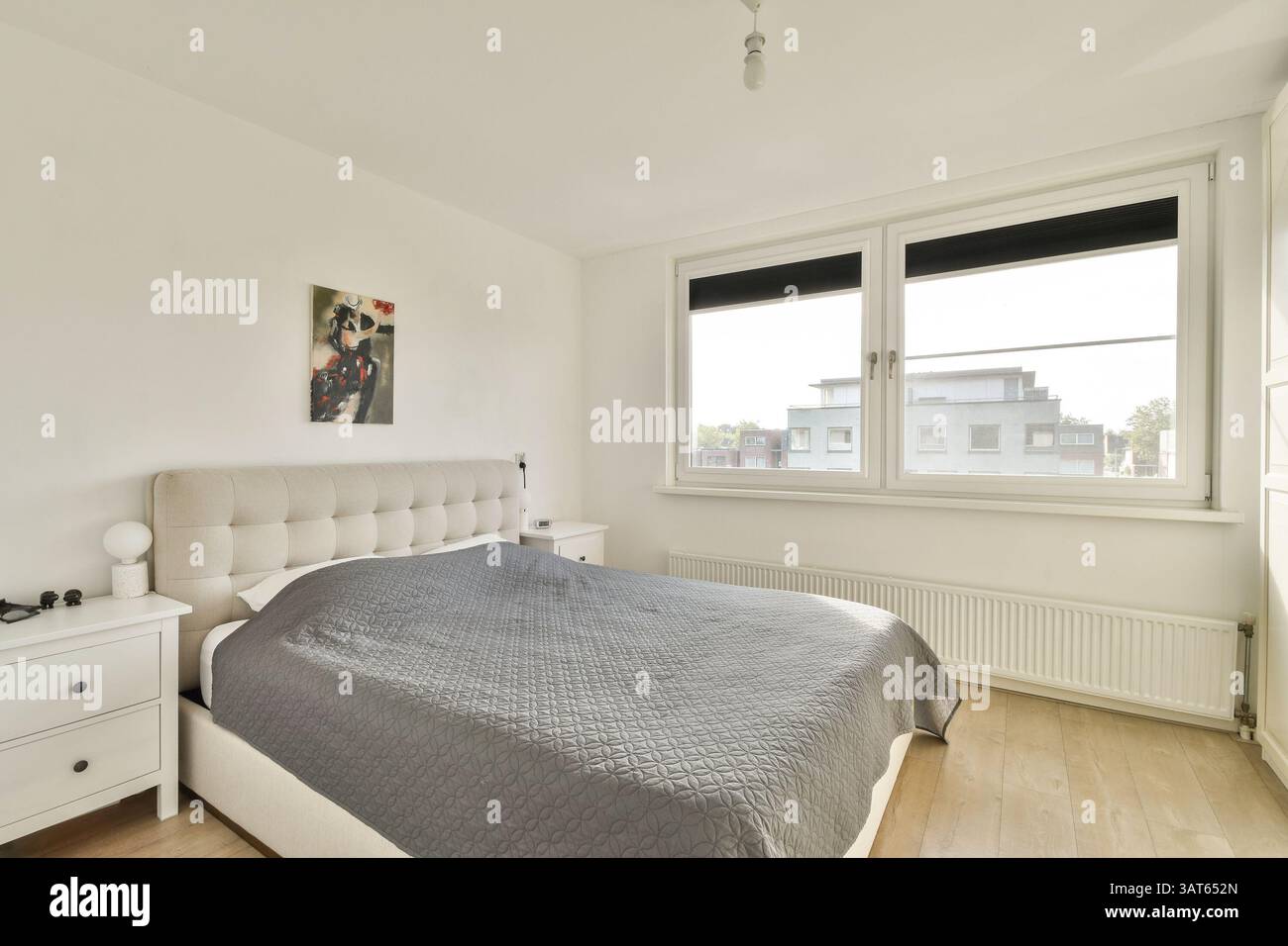 A modern bedroom showcases minimalist interior design with a plush bed ...