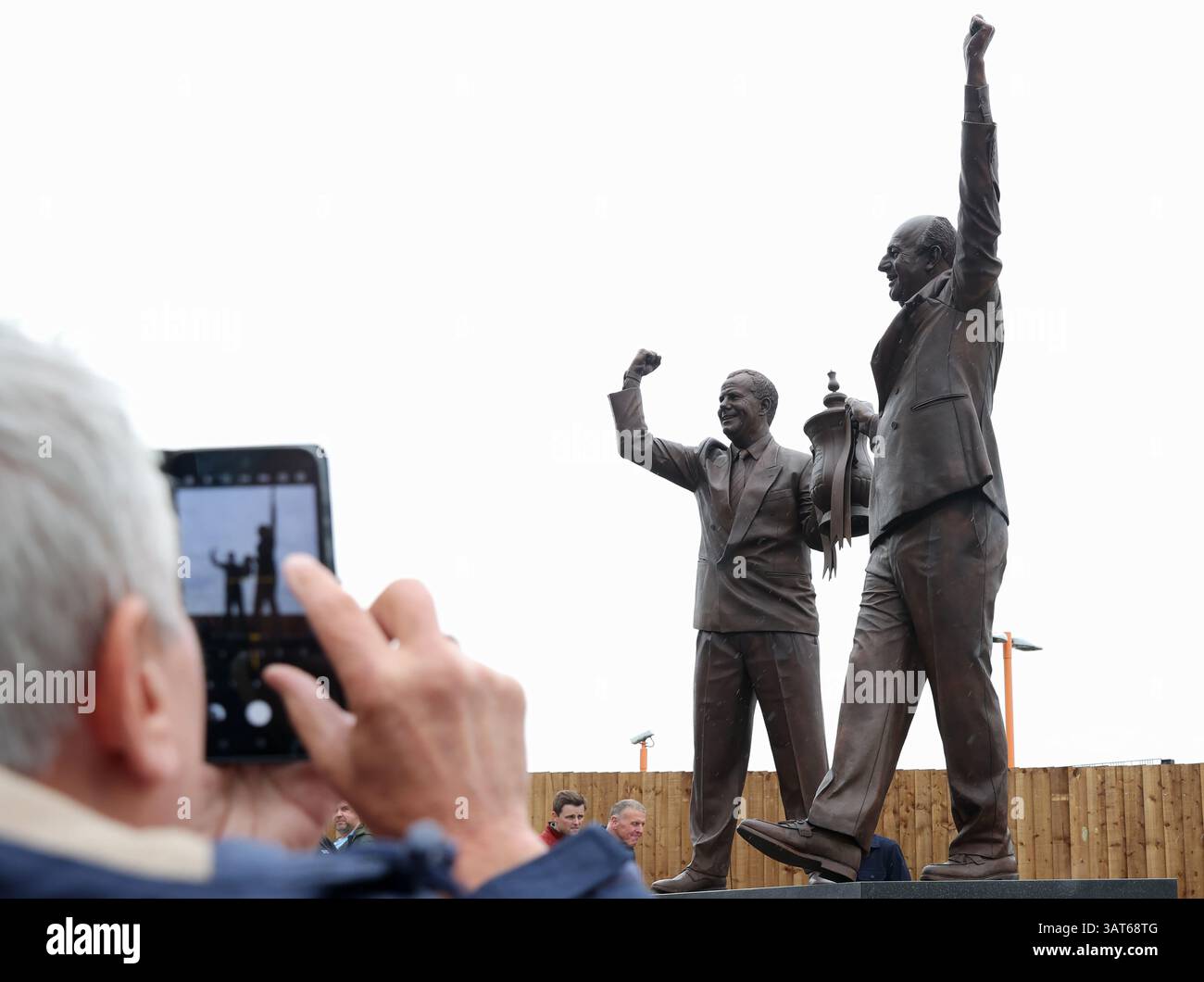 A fan takes a photograph of the statue of George Curtis and John ...