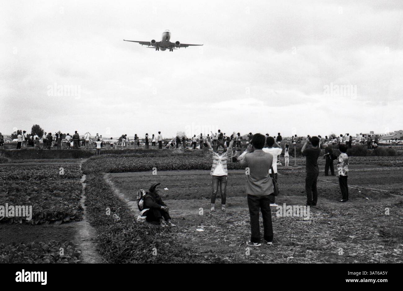 Crowd gathers in field to watch the majestic landing of a large ...