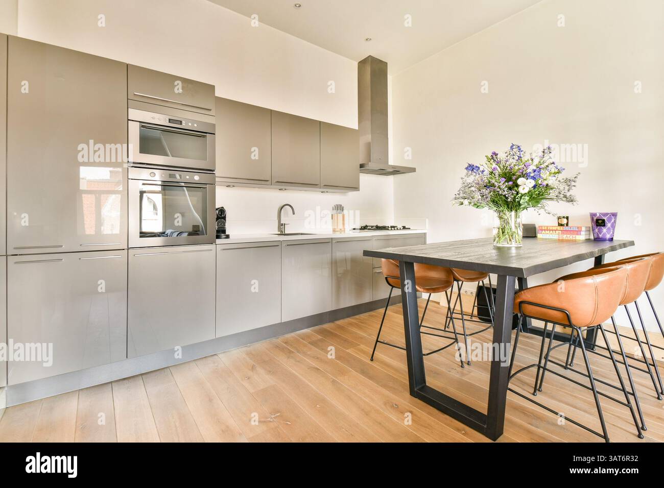 A sleek and contemporary kitchen interior featuring glossy cabinets, a ...