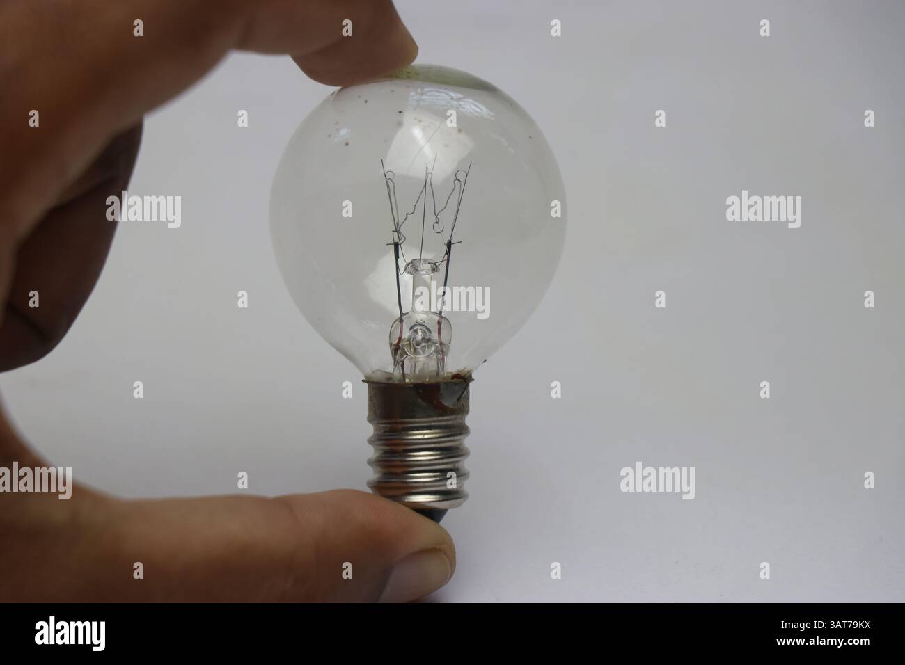 Incandescent light bulb held in the hand on a white background Stock ...