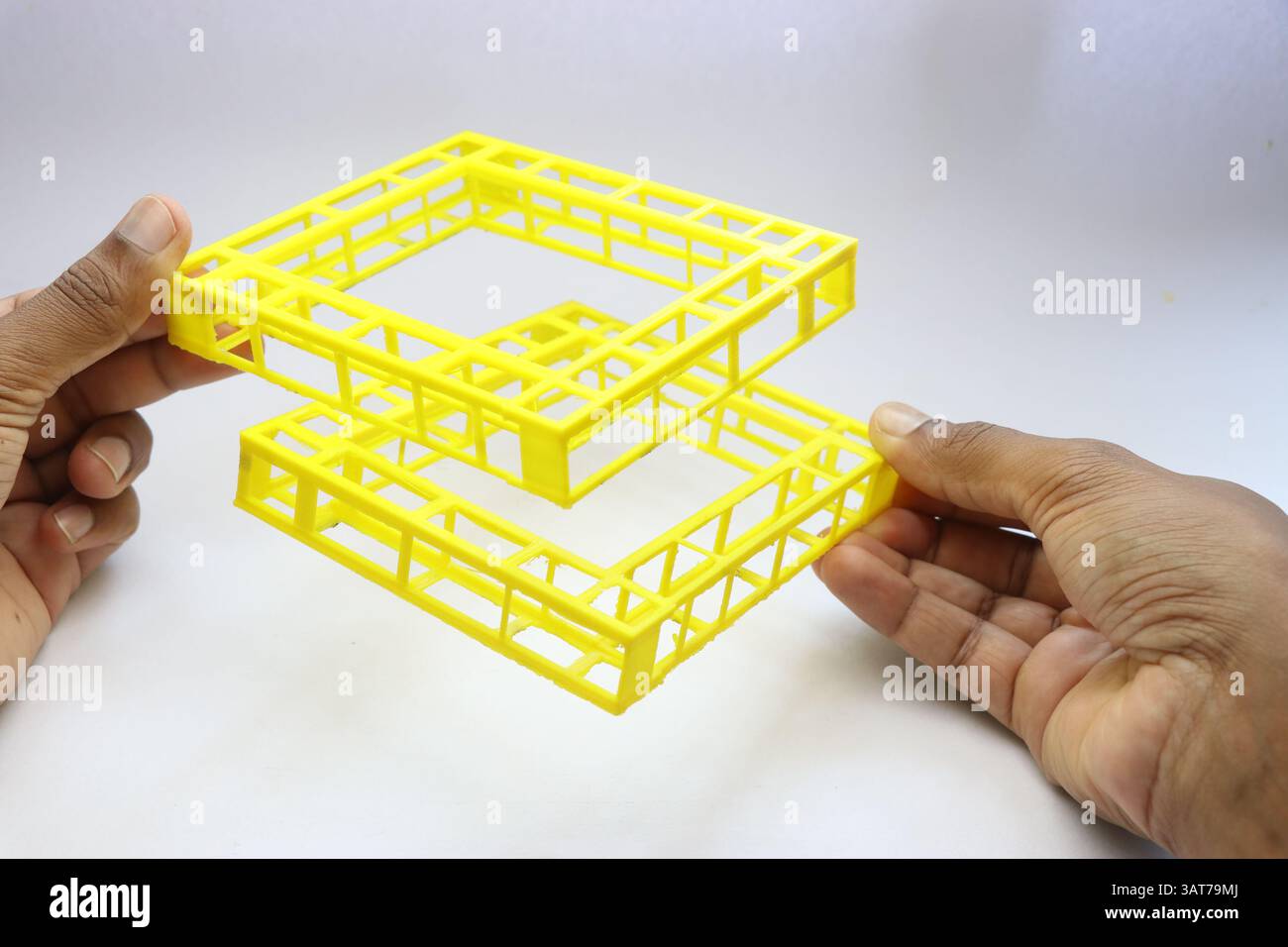 3D printed geo metrical shape object held in the hand on a white ...